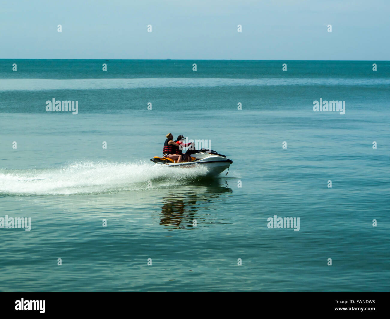two people drive jet skies in blue sea Stock Photo - Alamy