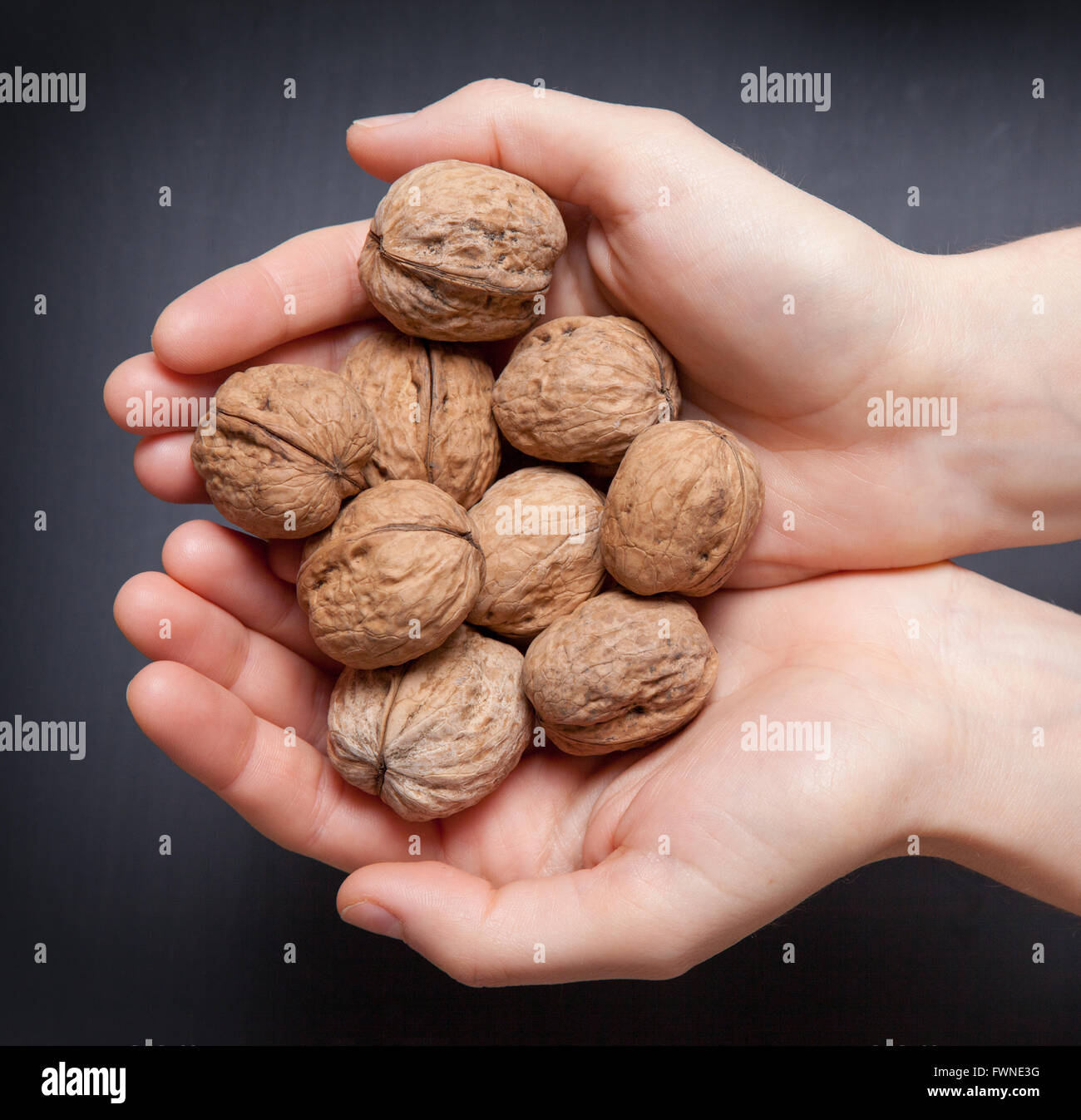 hands holding handful of walnuts Stock Photo - Alamy