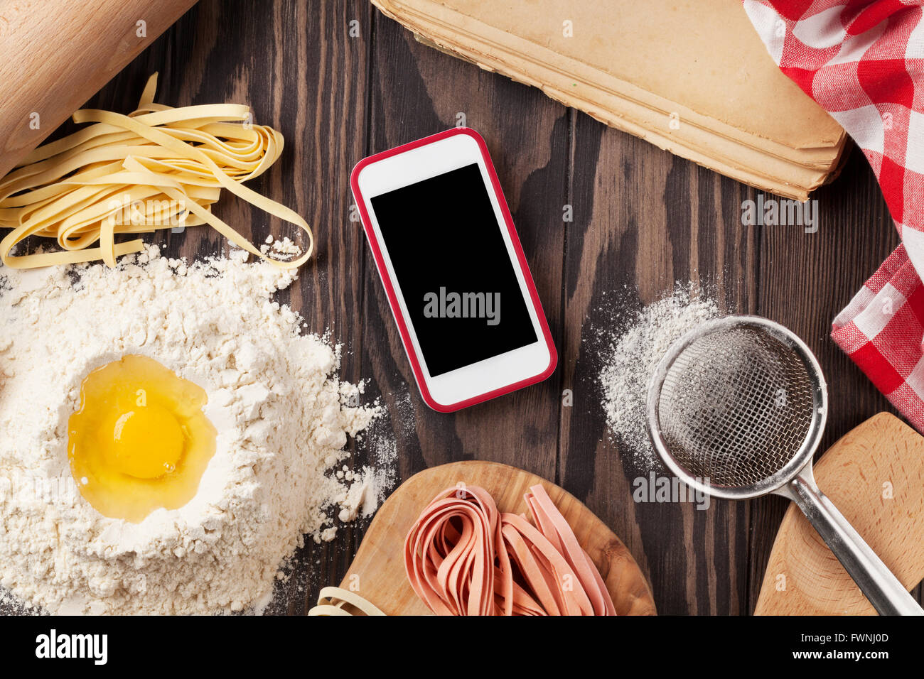 Homemade pasta cooking and smartphone with blank screen for your app ...