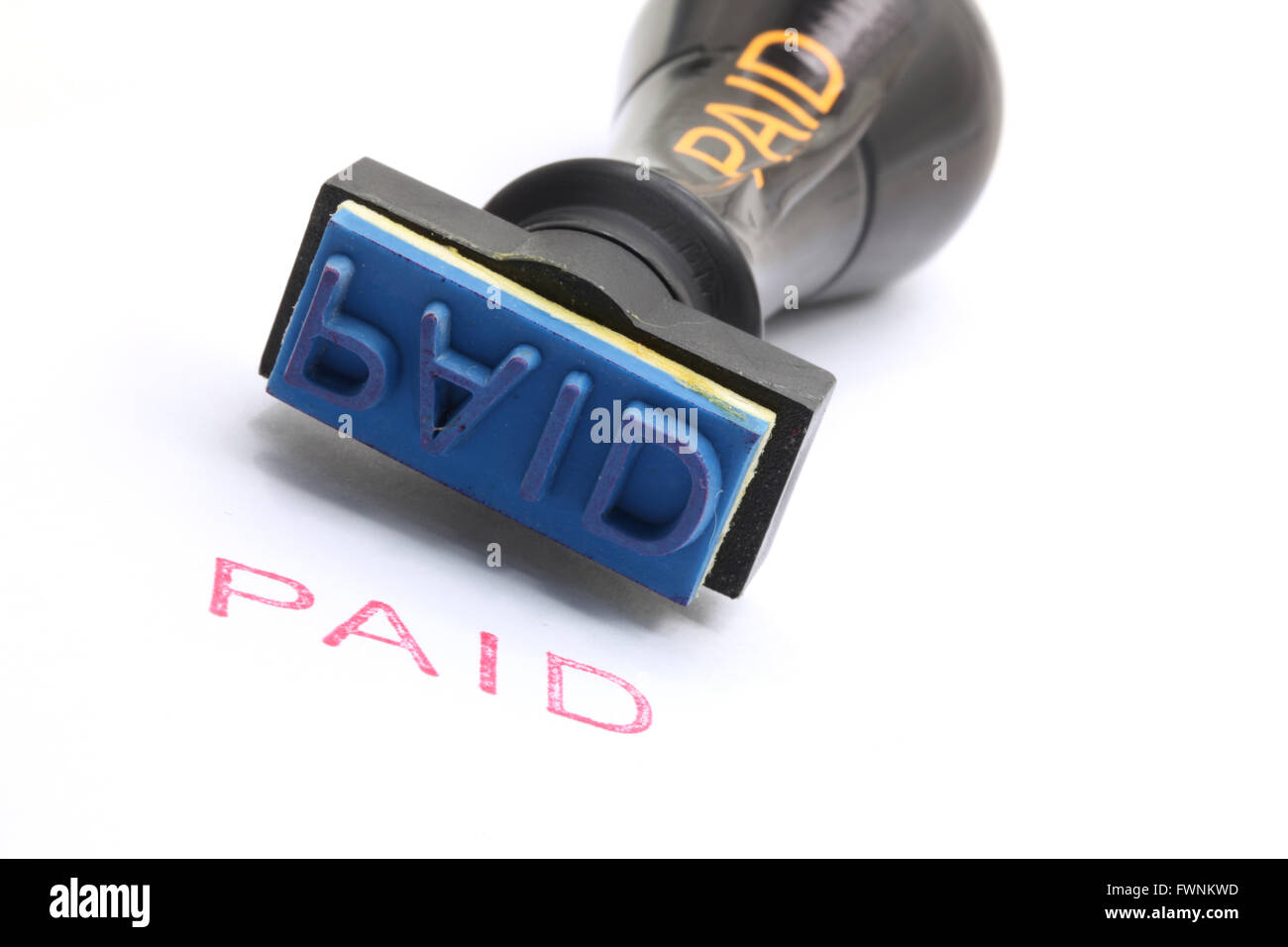 closeup of paid letter on rubber stamp isolated on white background ...