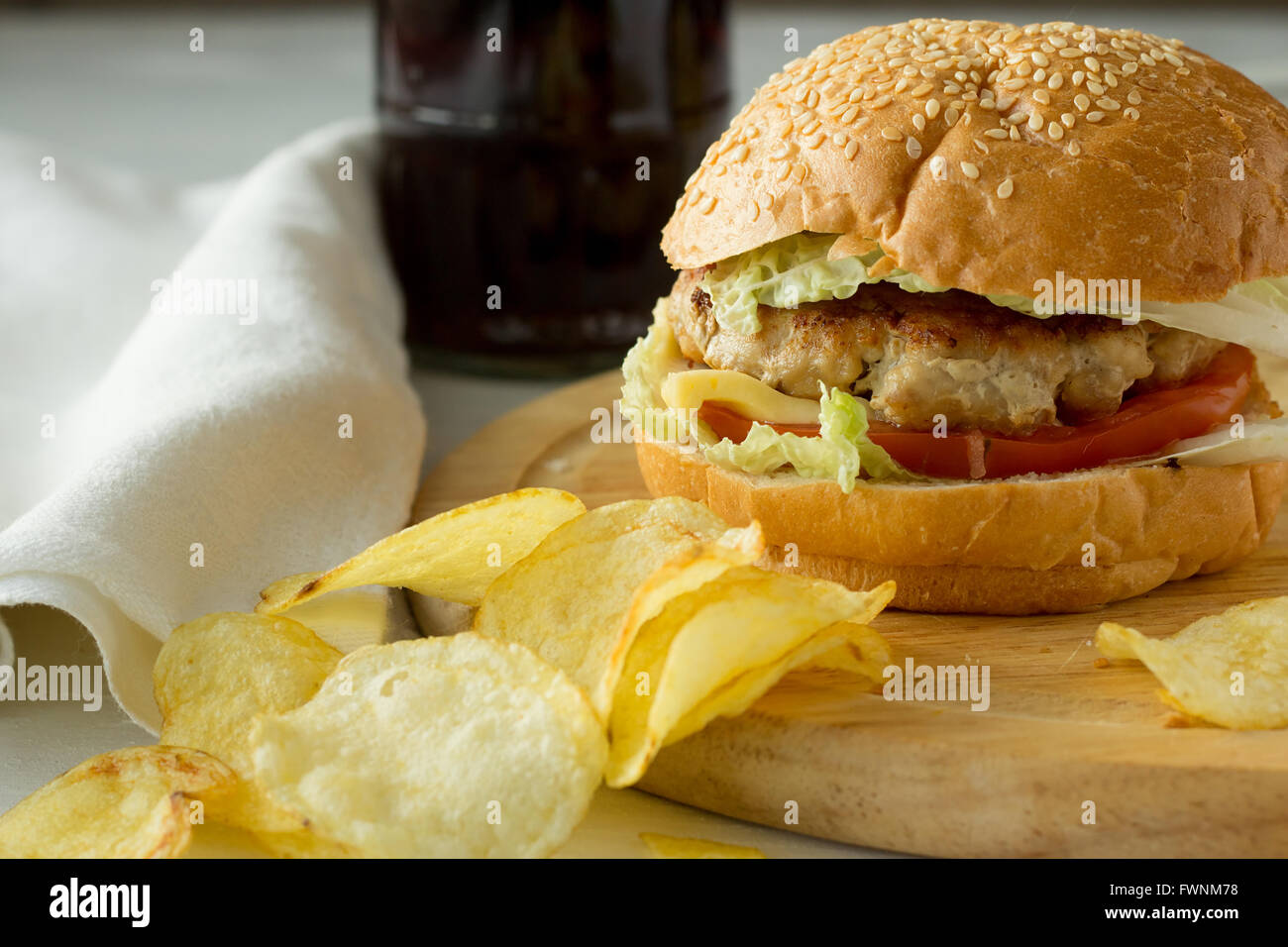 Cheeseburger on wooden plate and chips selective focus Stock Photo - Alamy