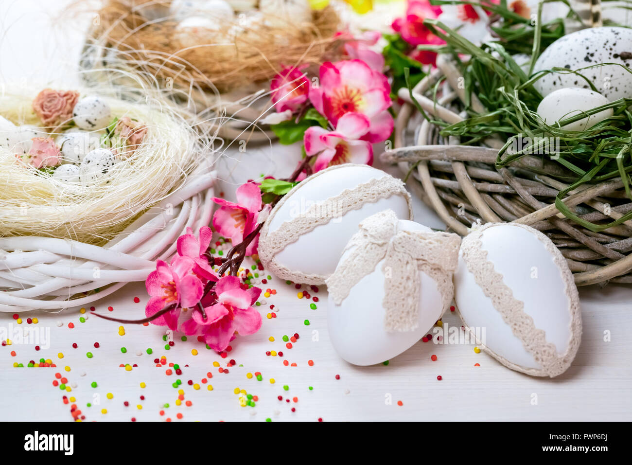 Beautiful Easter background with flowers and nest with eggs on white ...