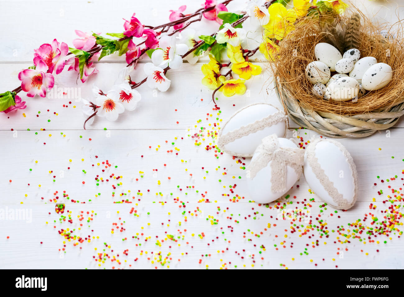 Beautiful Easter background with flowers and nest with eggs on white ...