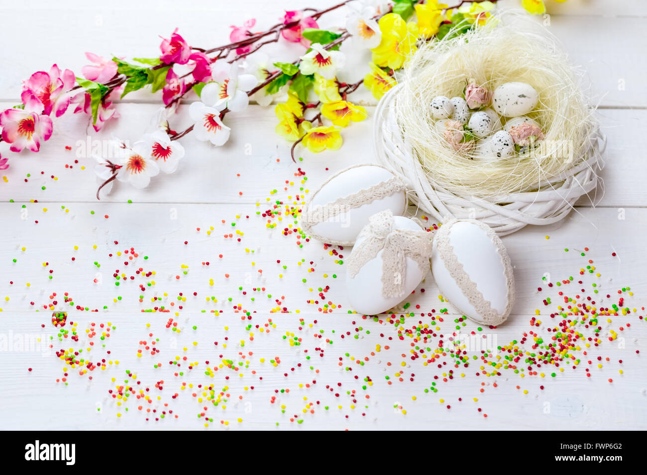 Beautiful Easter background with flowers and nest with eggs on white ...