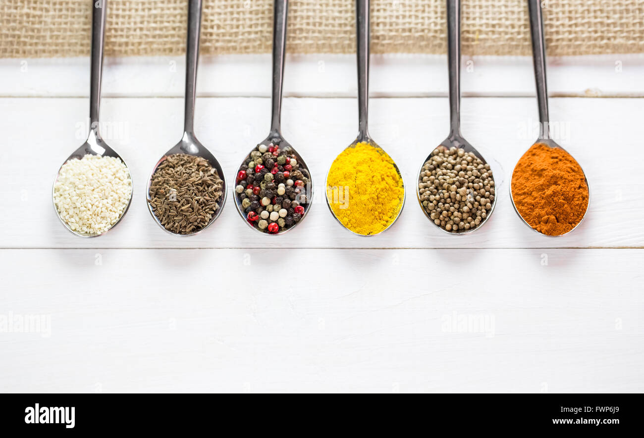 Beautiful colorful spices in an iron spoon on old wooden table white ...