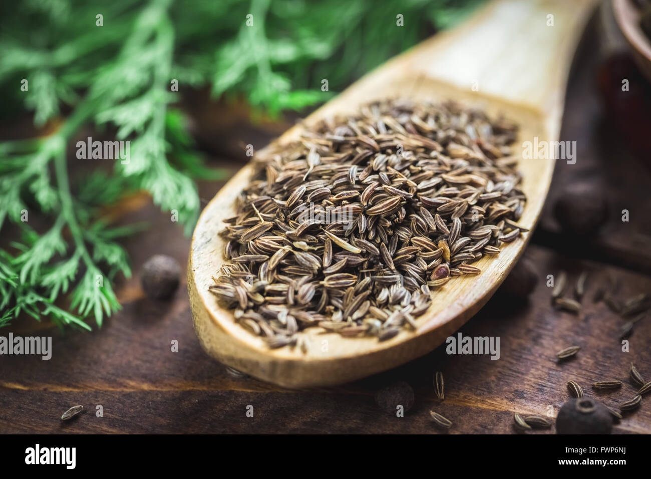 beautiful photo of cumin in wooden spoon on the background of the old ...