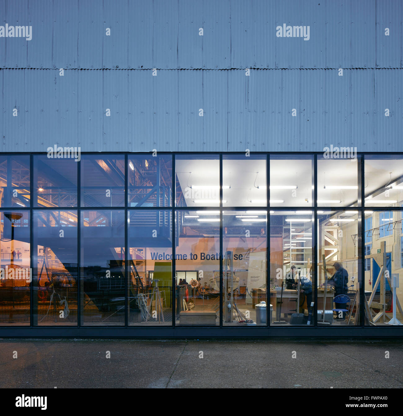 Full-height industrial window of boatbuilding workshop at dusk ...