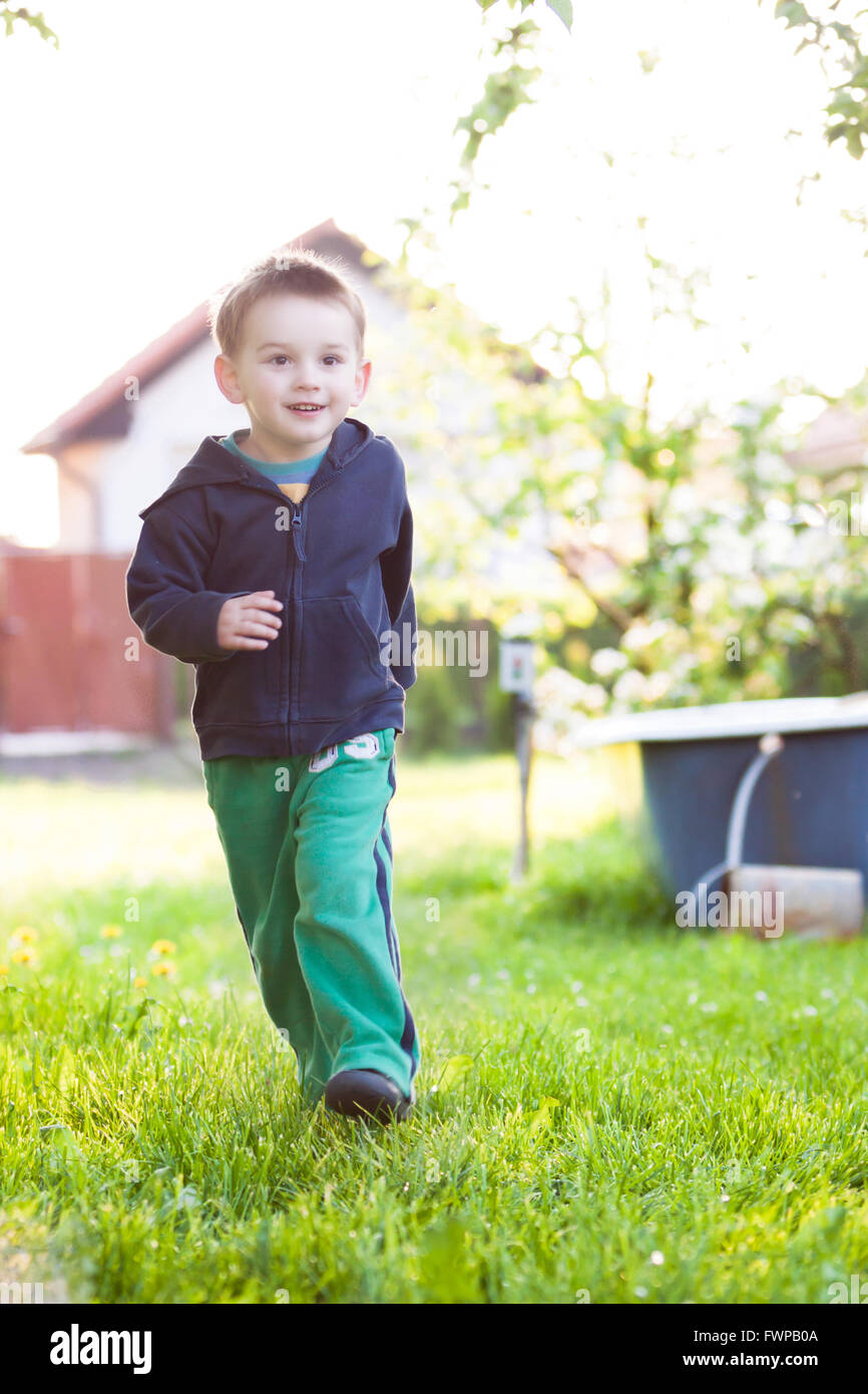 Running little boy in the garden Stock Photo - Alamy