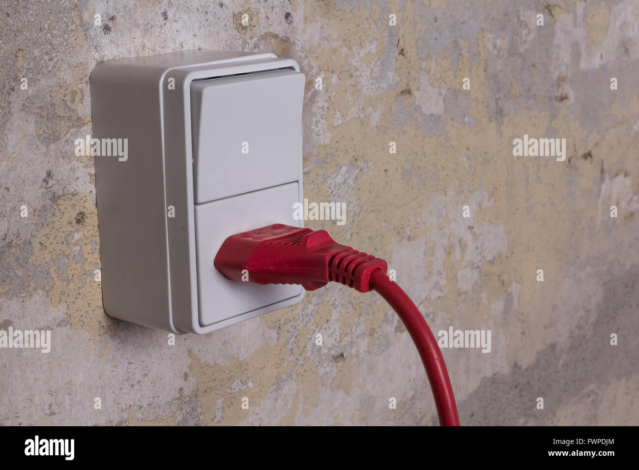 Side view of a red chord and plug in a white electrical socket Stock ...
