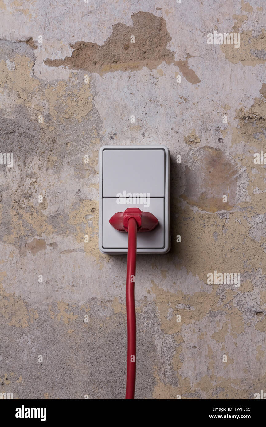 Red chord and plug in a white electrical socket Stock Photo - Alamy