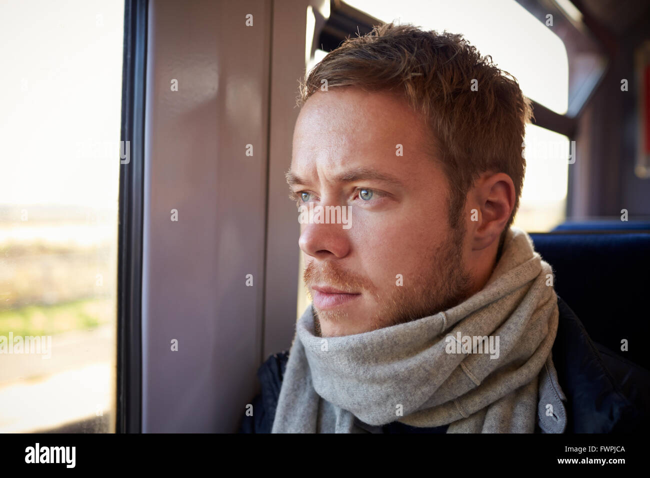 Young Man Sitting In Train Carriage On Railway Journey Stock Photo - Alamy