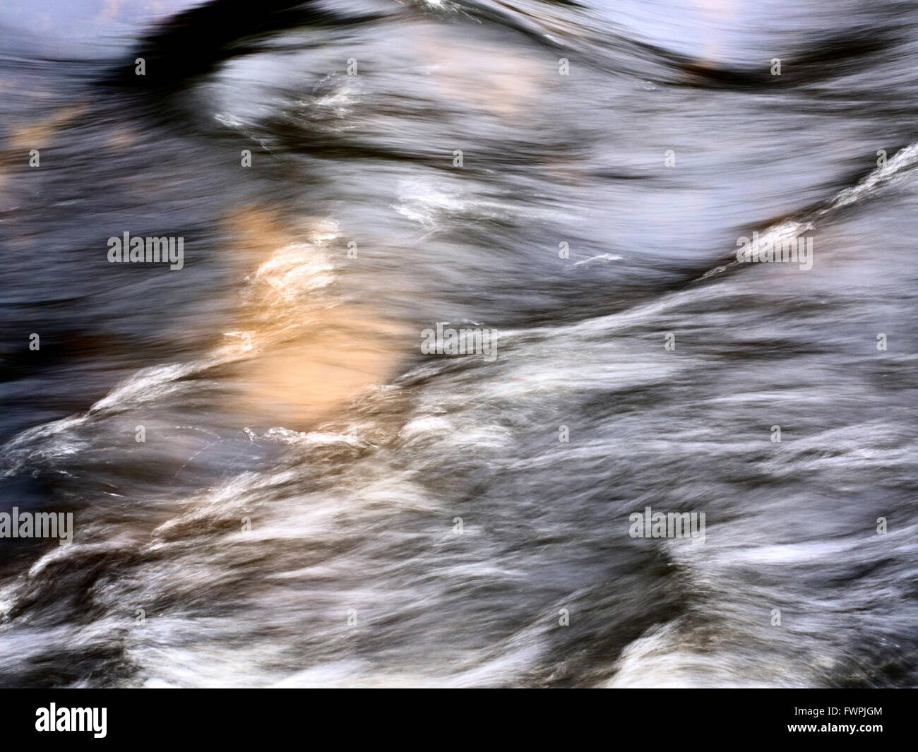 Abstract patterns formed by fast flowing water over a submerged rock in ...