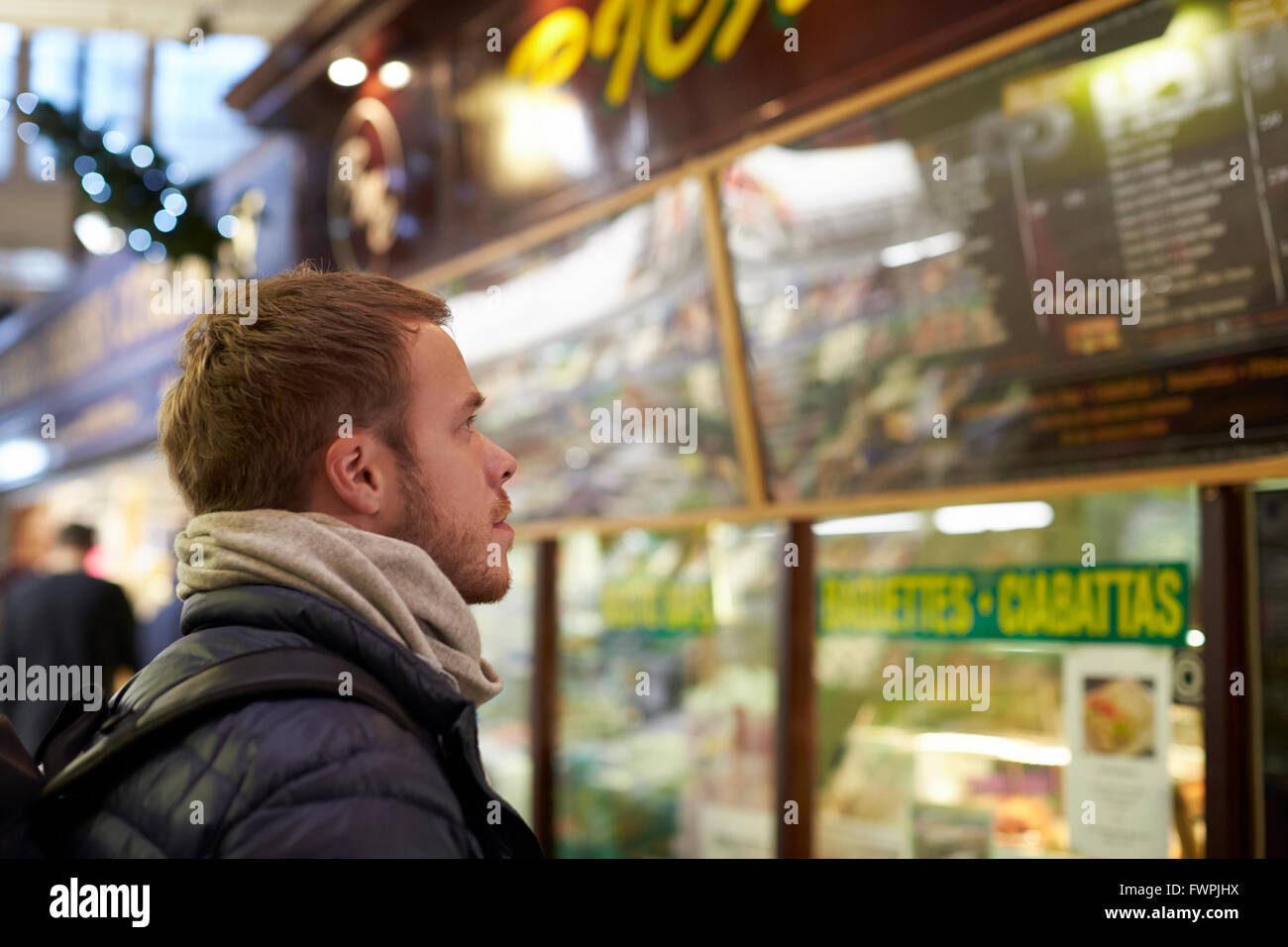 Young Man Looking In Shop Window Of Cafe Stock Photo - Alamy