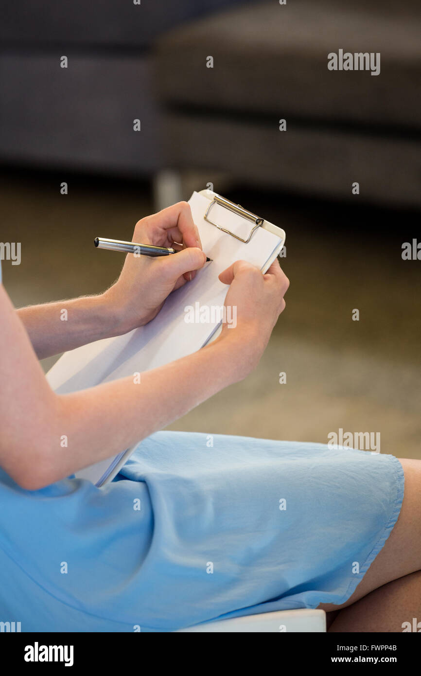 Woman writing note on clipboard Stock Photo - Alamy