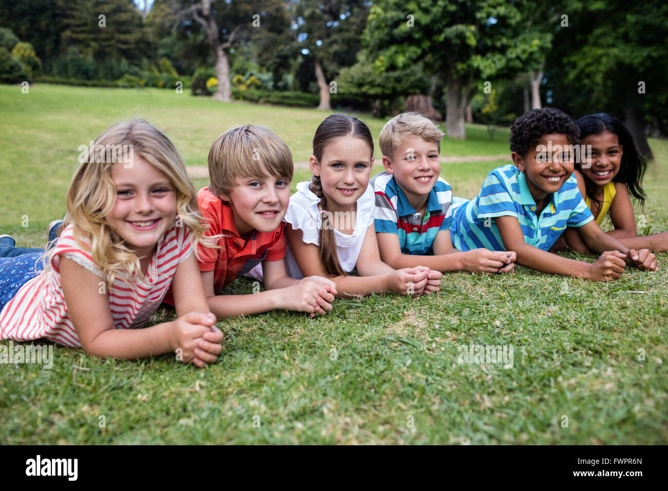 Happy children lying on grass Stock Photo - Alamy