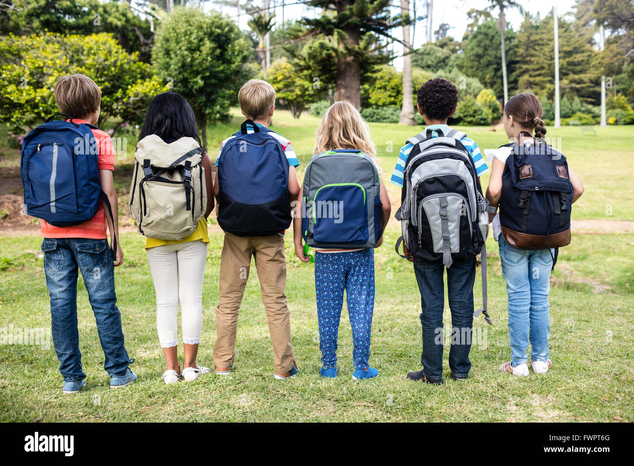 Rear view of children with bags standing together Stock Photo - Alamy