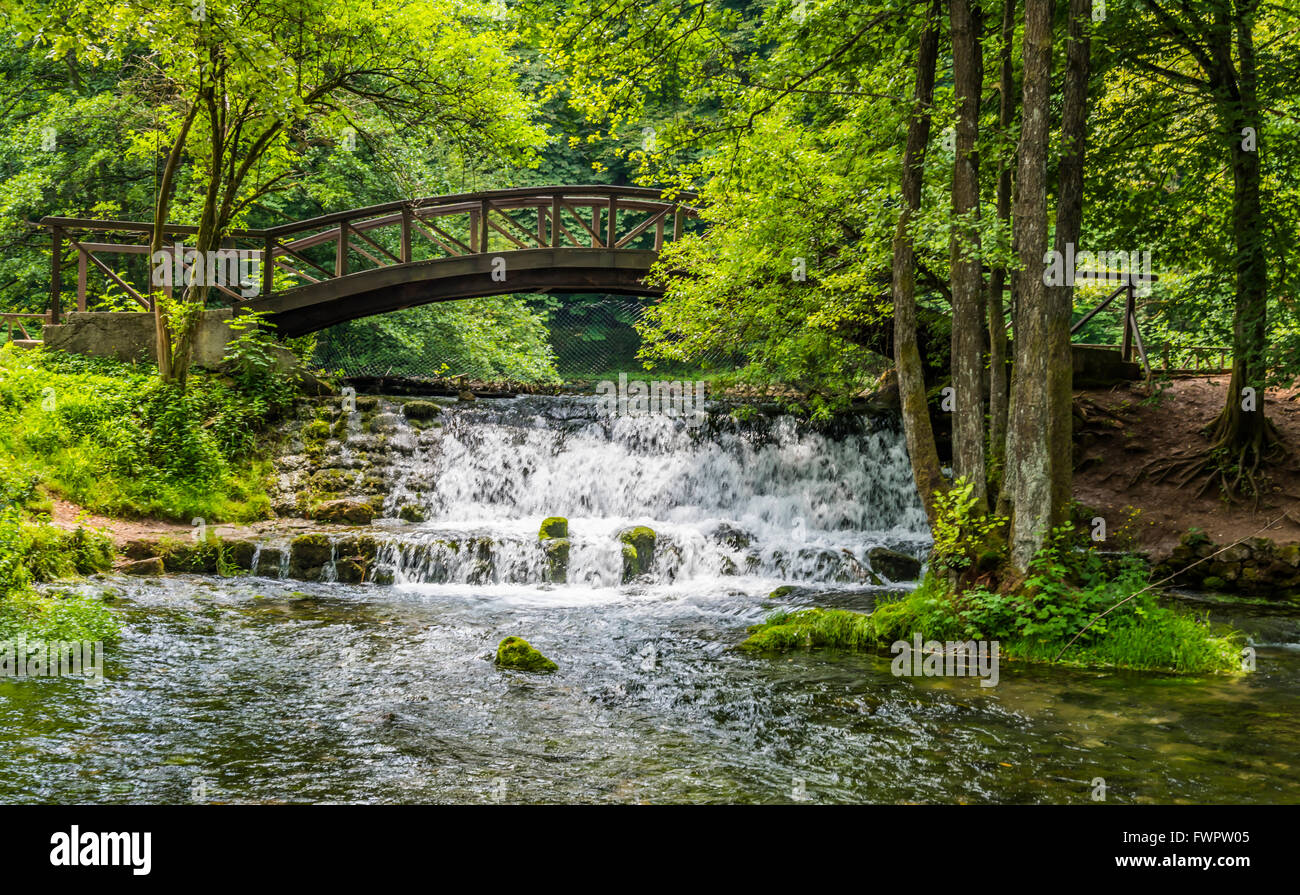 Wooden bridge over river's waterfall Stock Photo - Alamy