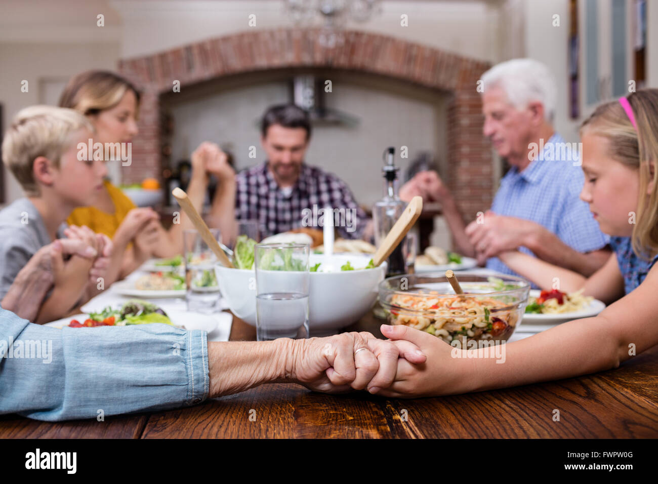 Multi-generation family praying before having meal Stock Photo - Alamy