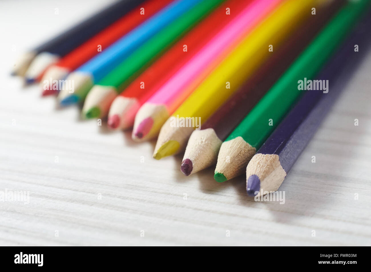 Stack of colored pencils on white table. Studio shot Stock Photo - Alamy
