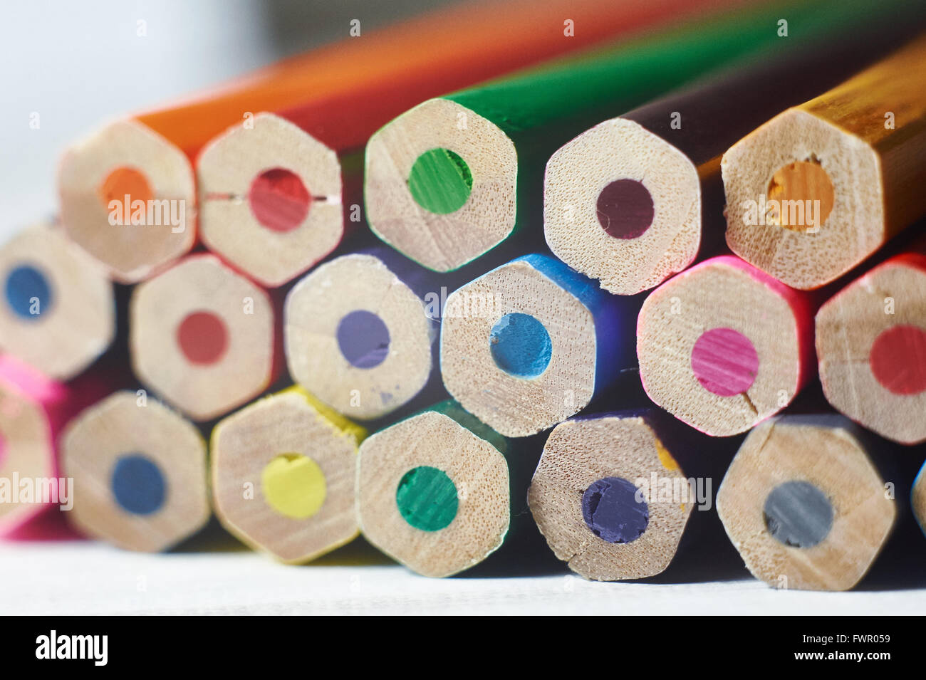 Stack of colored pencils on white table. Studio shot Stock Photo - Alamy