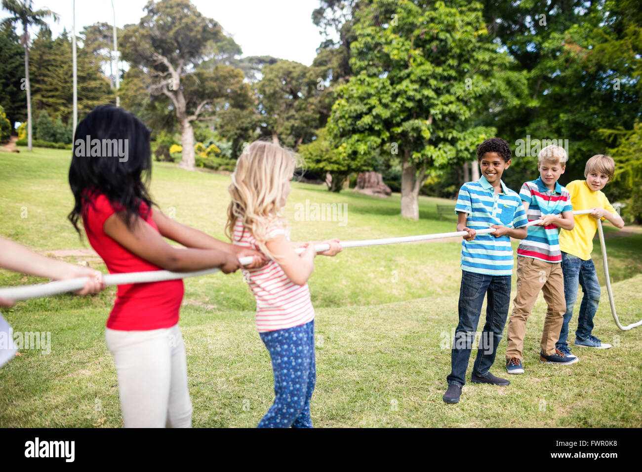 Children pulling a rope in tug of war Stock Photo - Alamy
