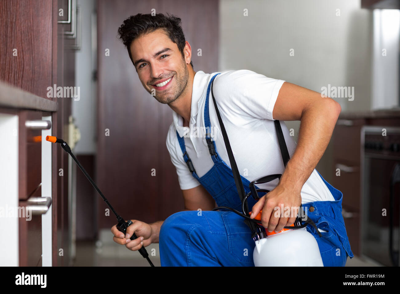 Portrait of confident pesticide worker crouching Stock Photo - Alamy