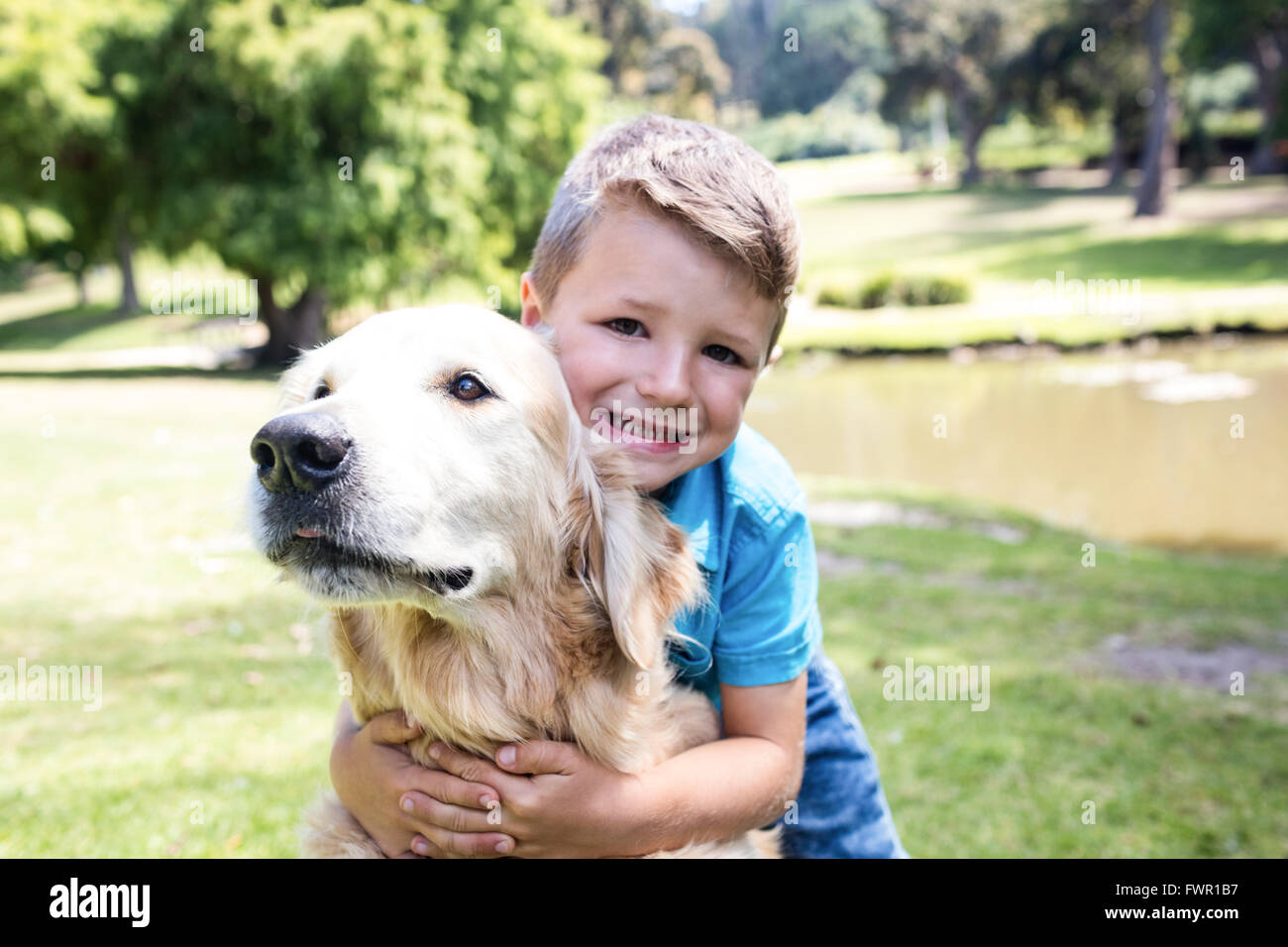 Smiling boy with his pet dog in the park Stock Photo - Alamy