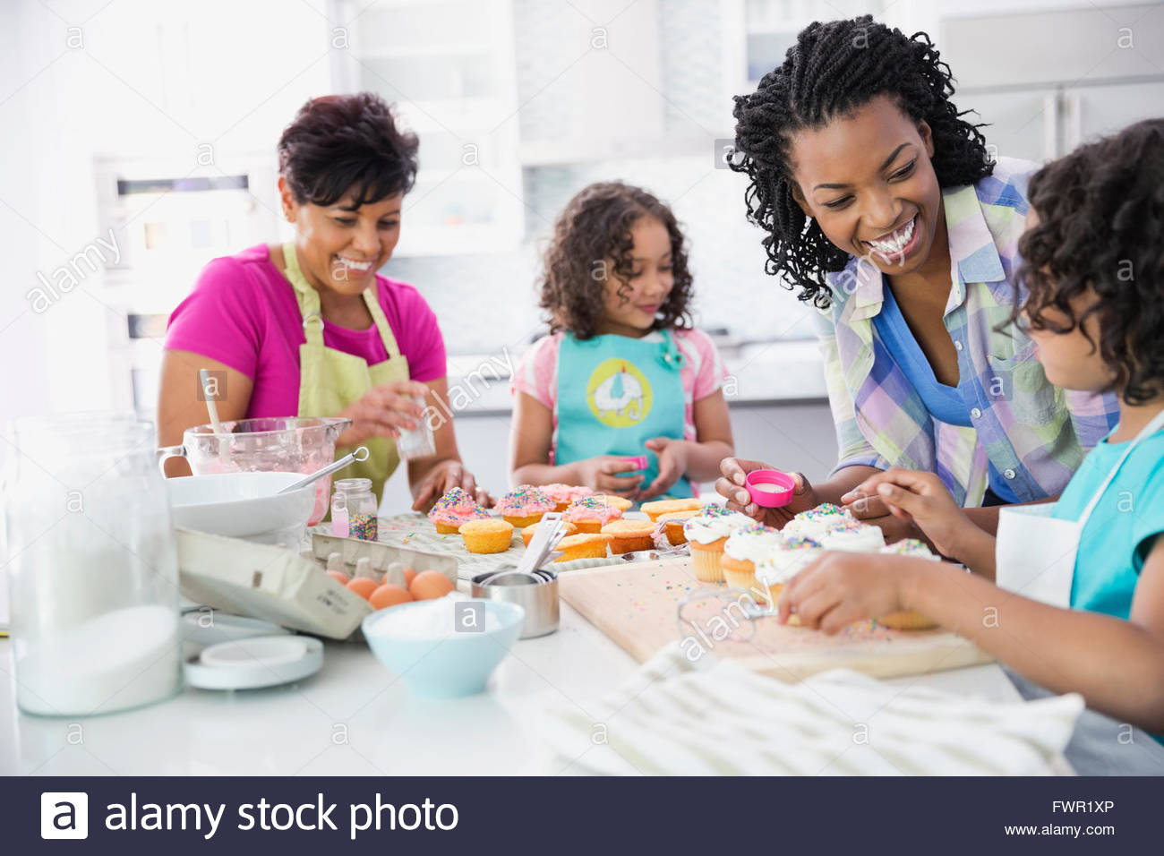 Multi-generation females making cupcakes together Stock Photo - Alamy