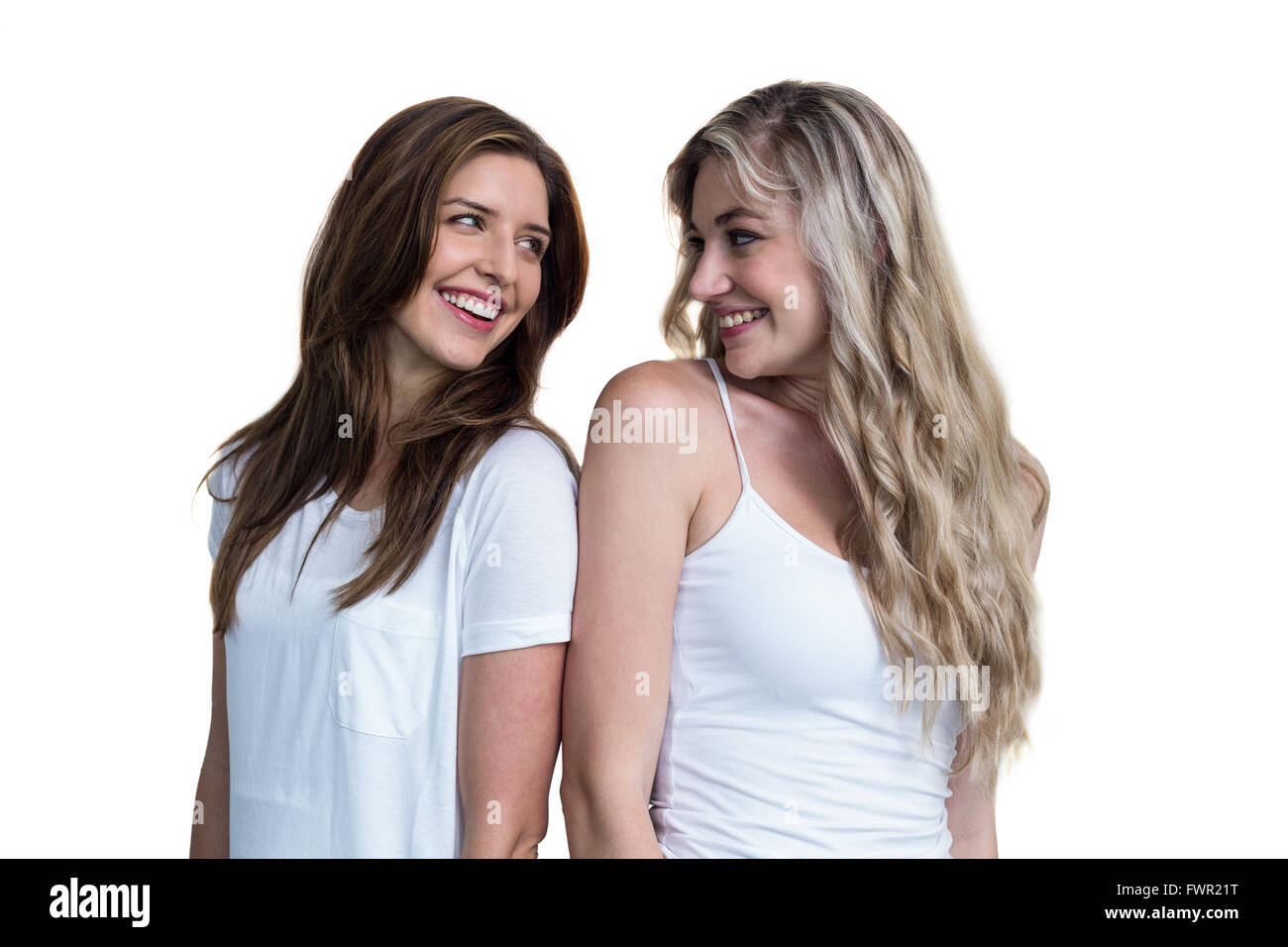 Happy young female friends standing back-to-back Stock Photo - Alamy