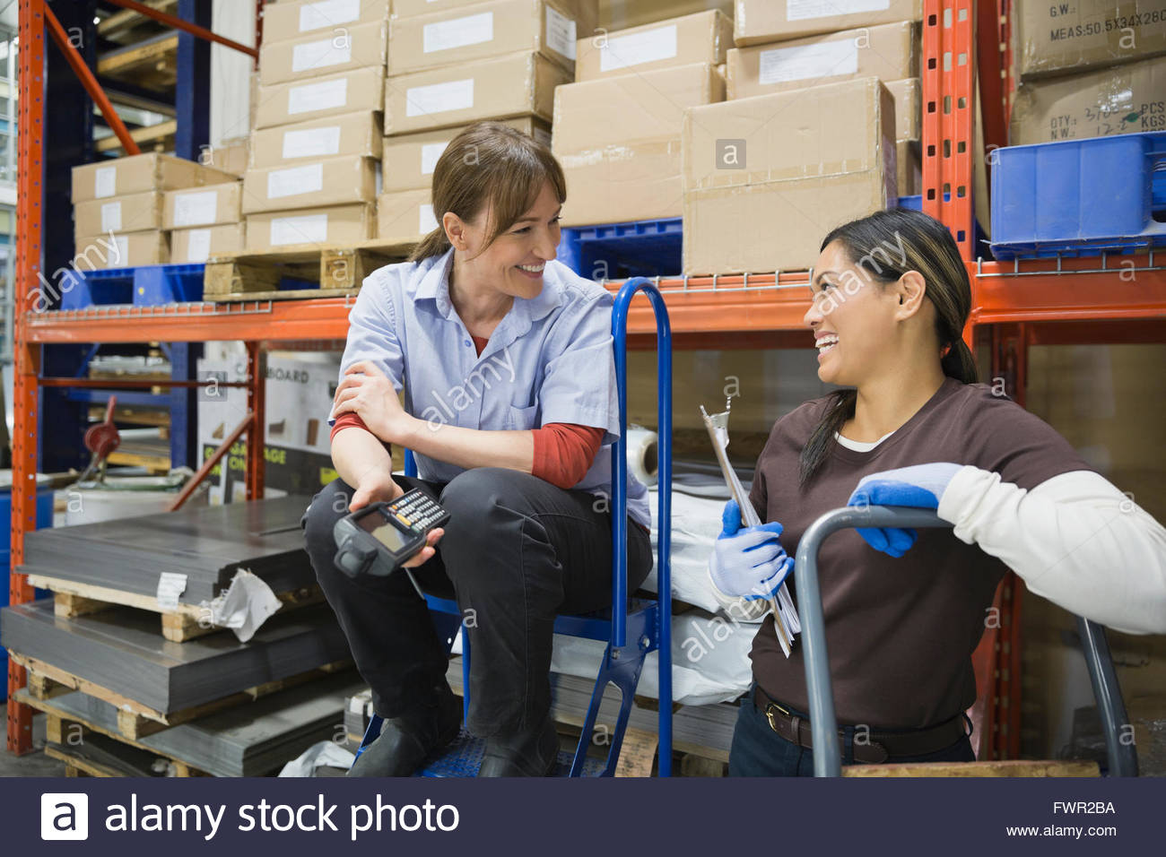 Workers talking in warehouse Stock Photo - Alamy