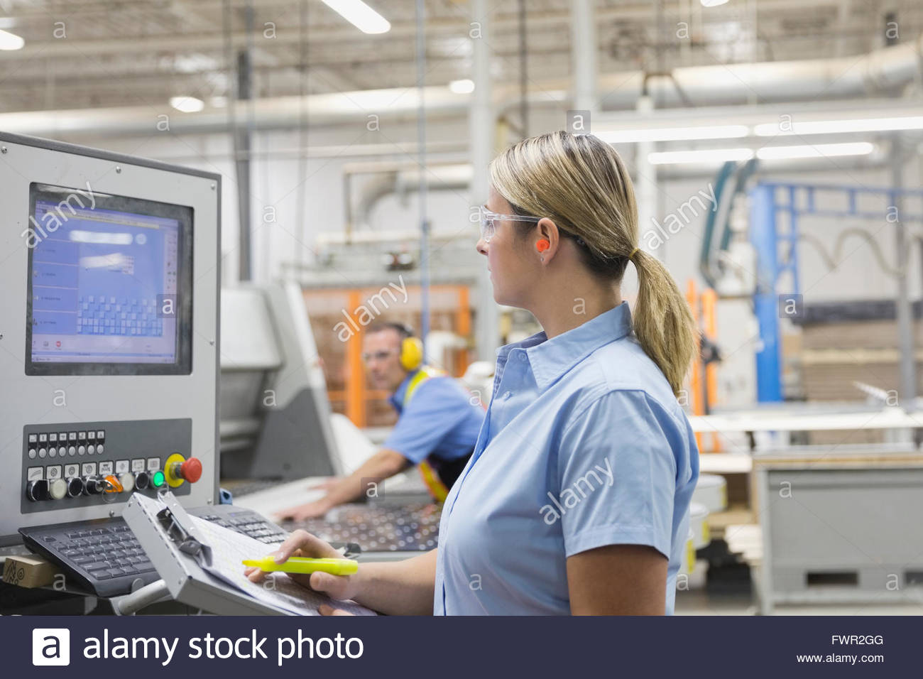 Worker looking at computer in warehouse Stock Photo - Alamy