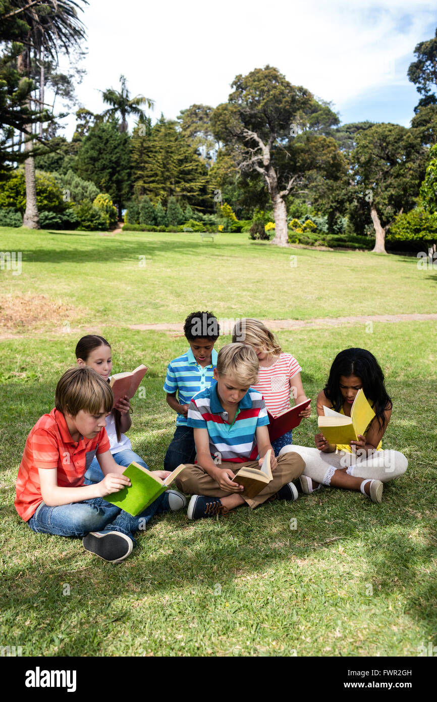 Children reading book in the park Stock Photo - Alamy