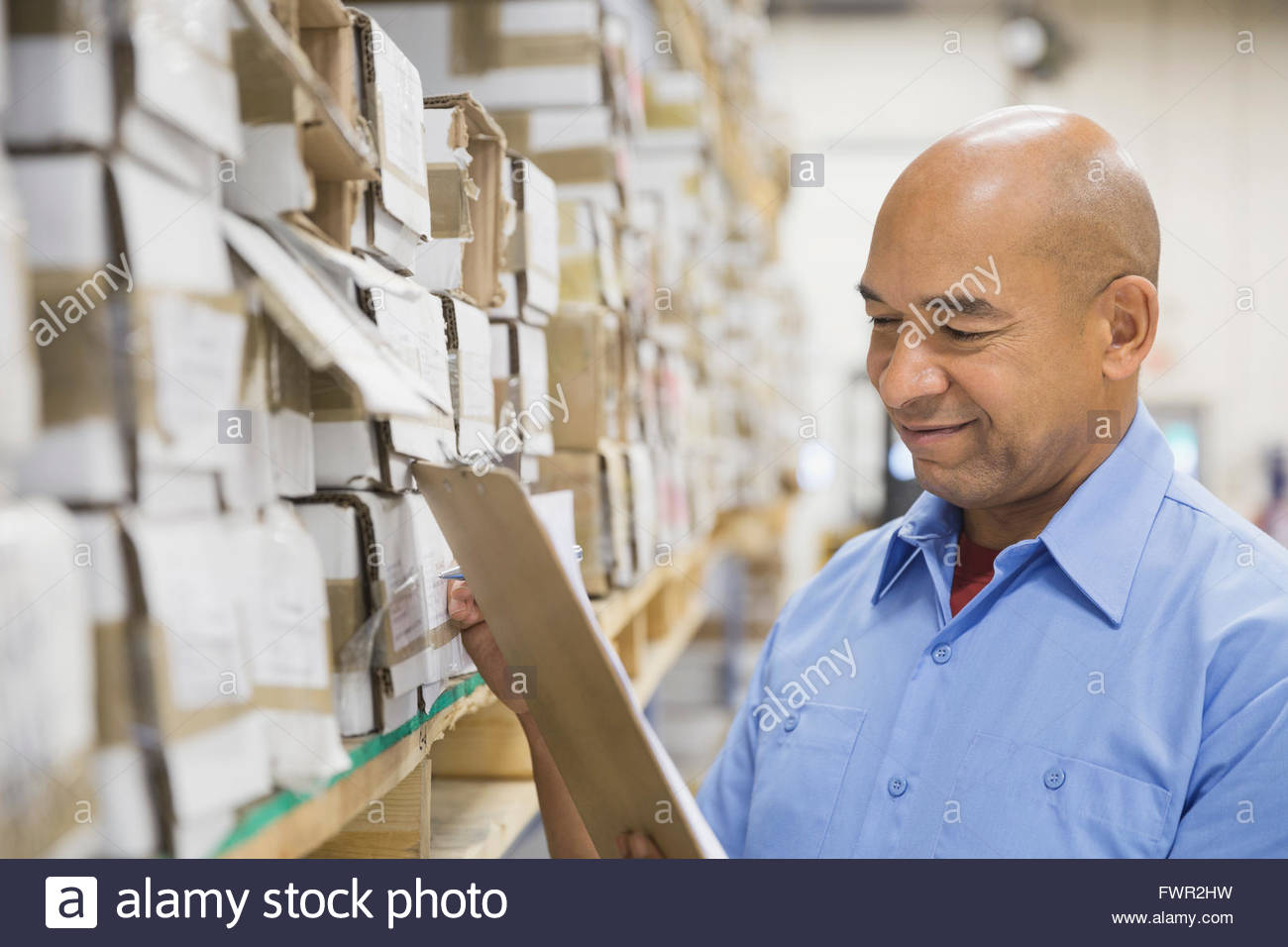 Worker reading checklist in warehouse Stock Photo - Alamy