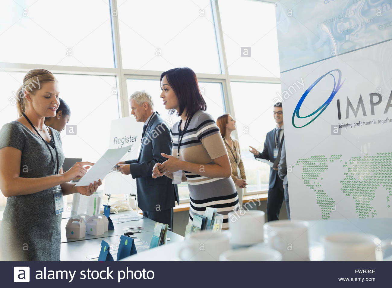 Businesswoman assisting attendee during conference Stock Photo - Alamy