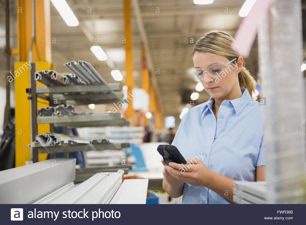 Worker using smart phone in warehouse Stock Photo - Alamy