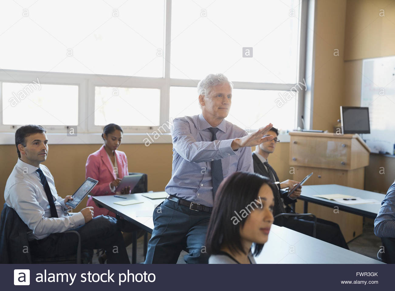 Instructor explaining to adult students in training class Stock Photo ...