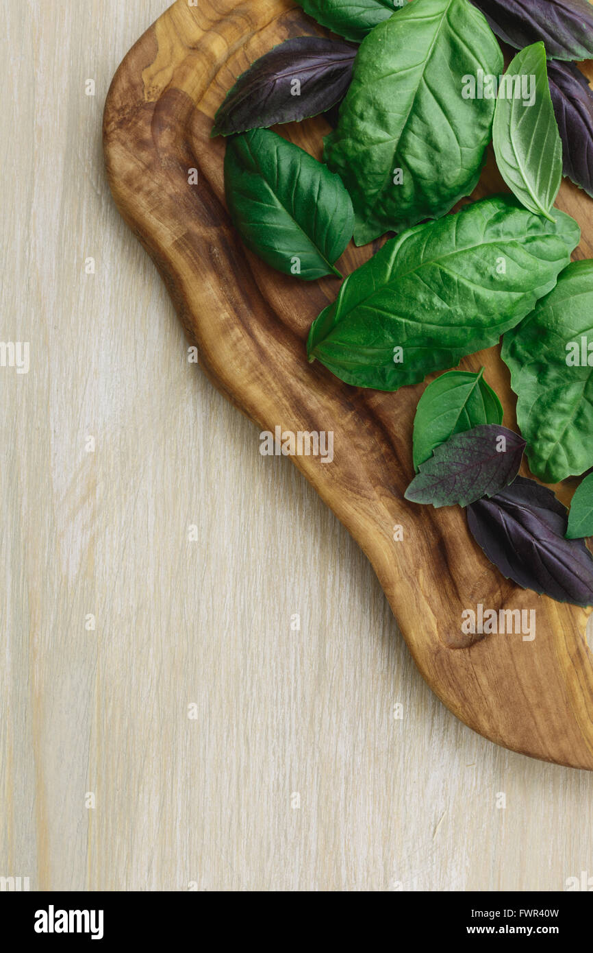 Heirloom basil on olive wood cutboard. The cultivars including Genovese ...