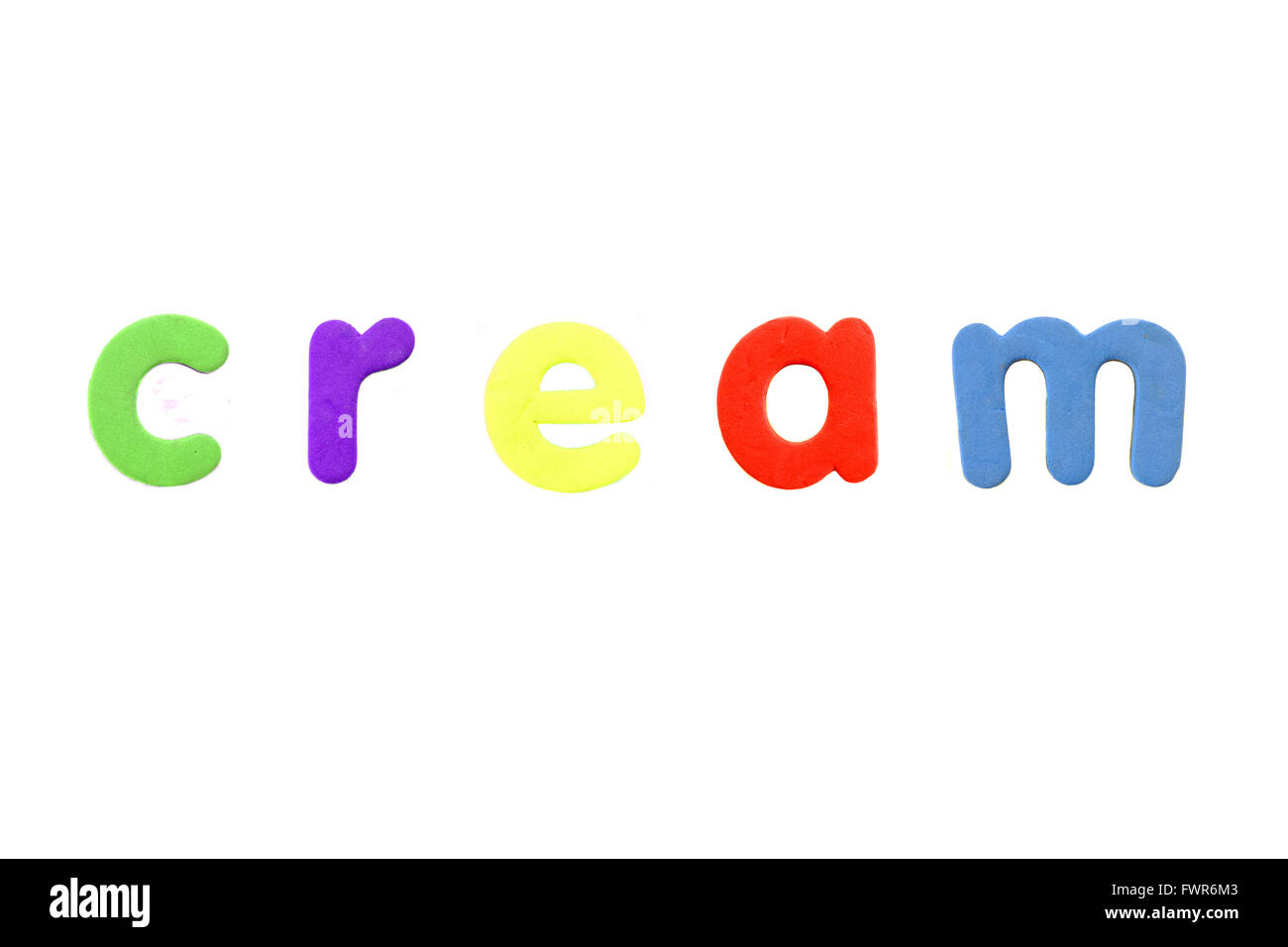 The word cream created from alphabetic fridge magnets against a white ...