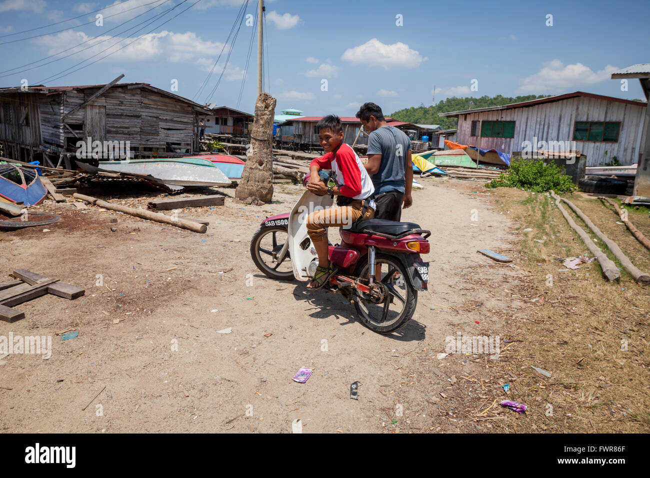 Boys or youths on a motorbike, in a remote village in the Pitas area of ...