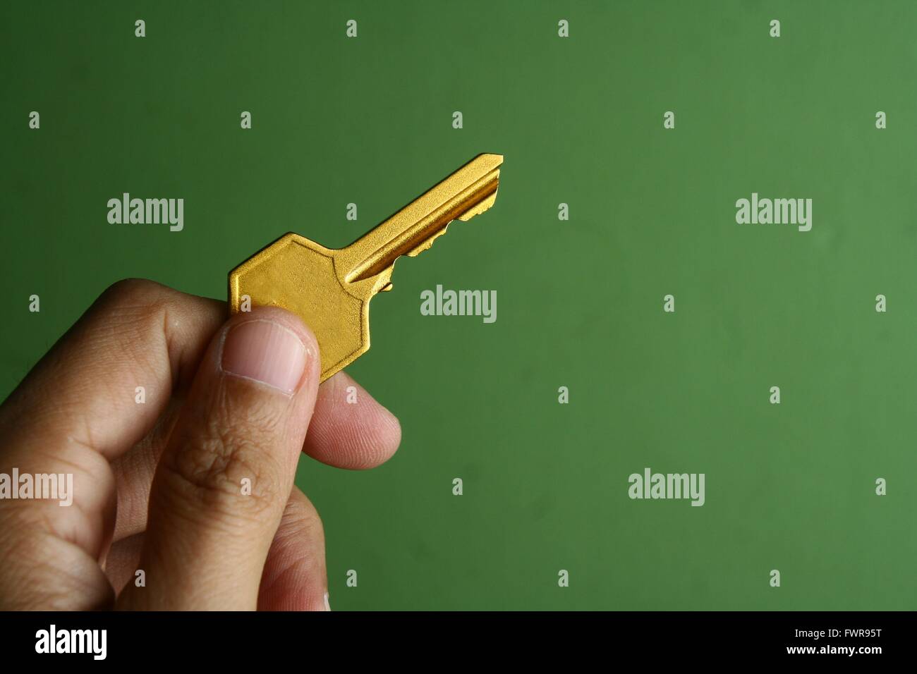 Golden key held in hand Stock Photo - Alamy