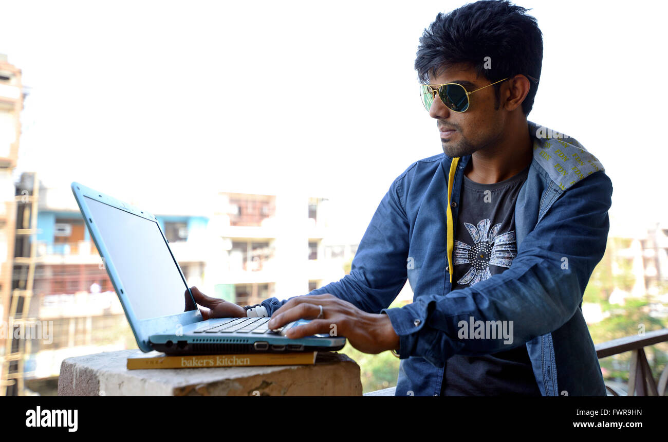 Indian young man using laptop at coffee break Stock Photo - Alamy