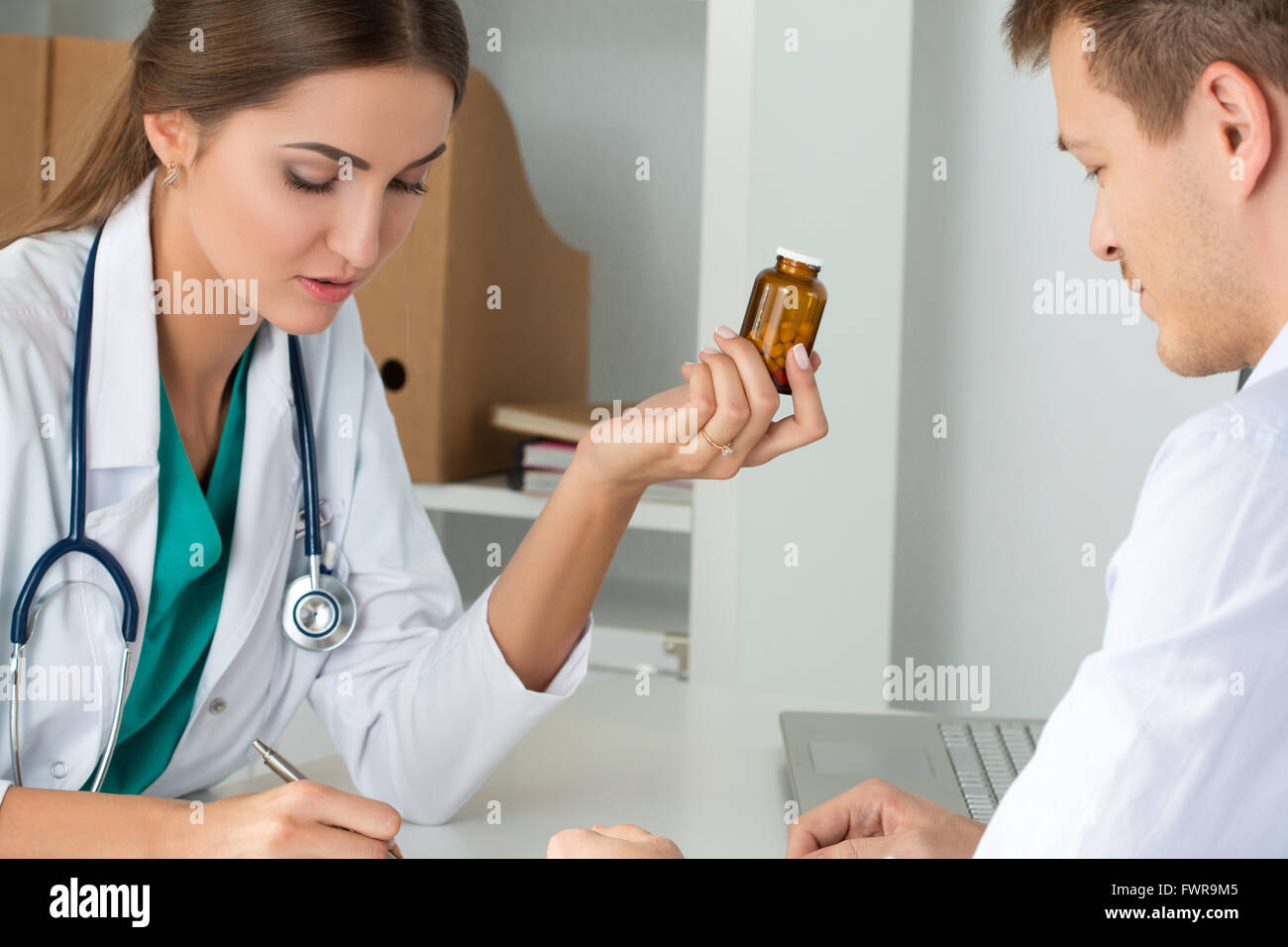 Female medicine doctor prescribing pills to her male patient ...