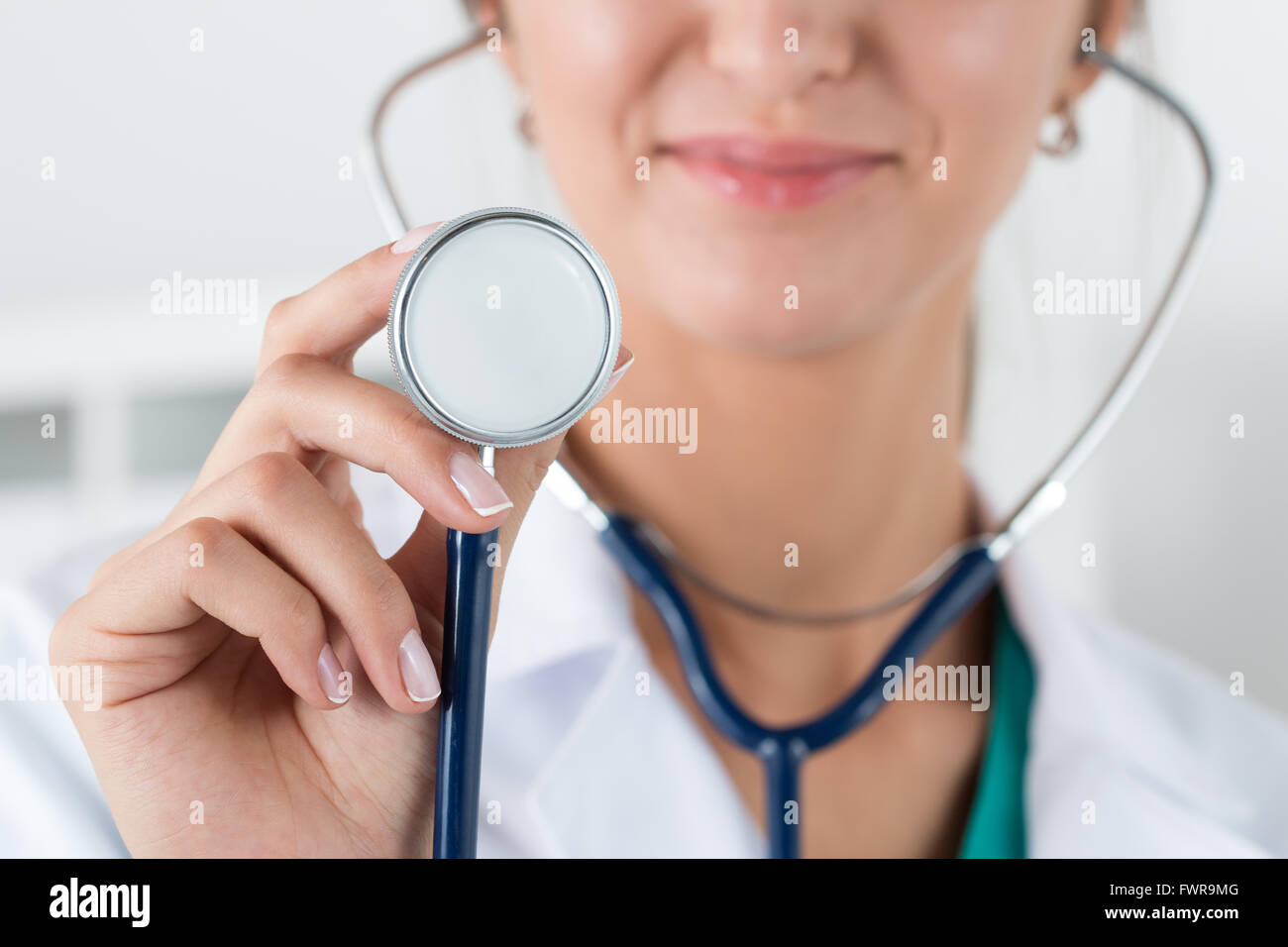 Portrait of beautiful female doctor holding stethoscope head ready to ...