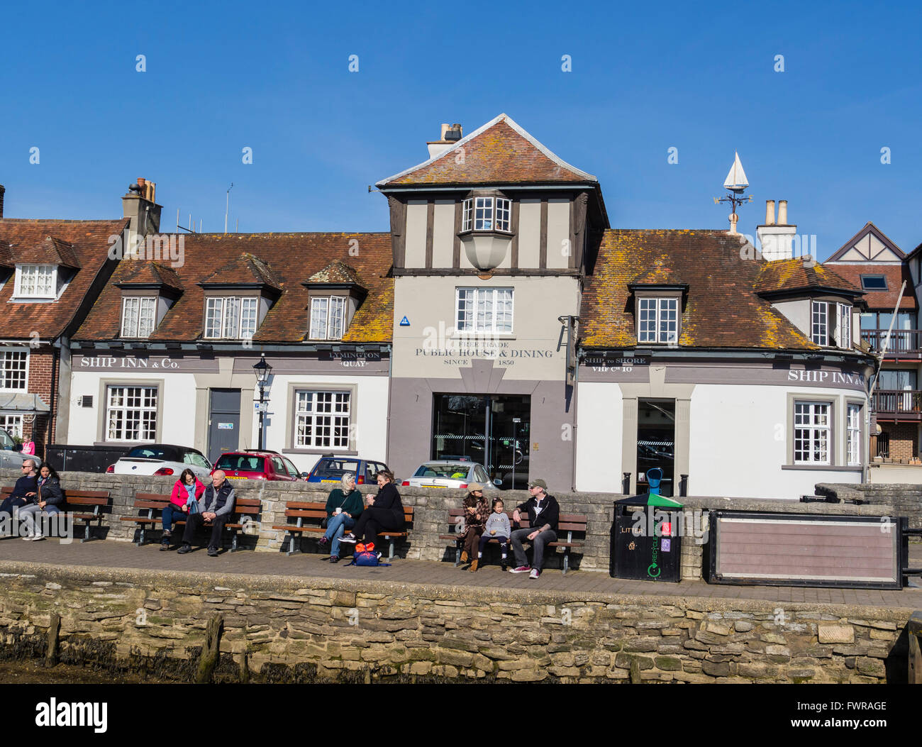 Lymington Quay with people sitting at the quayside and the Ship Inn ...