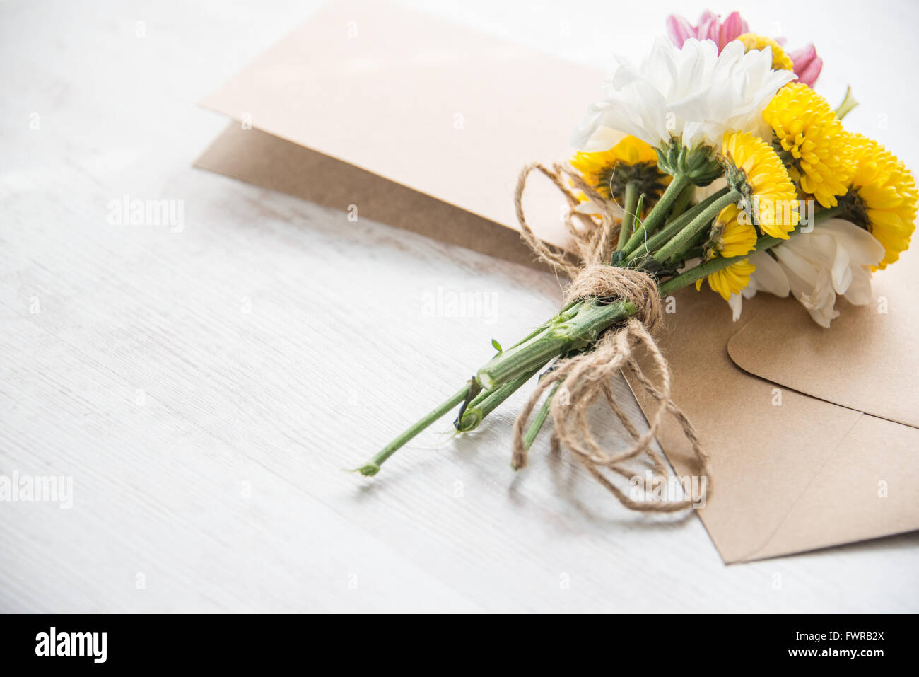 Spring flowers bouquet with kraft card note and envelope on a white ...