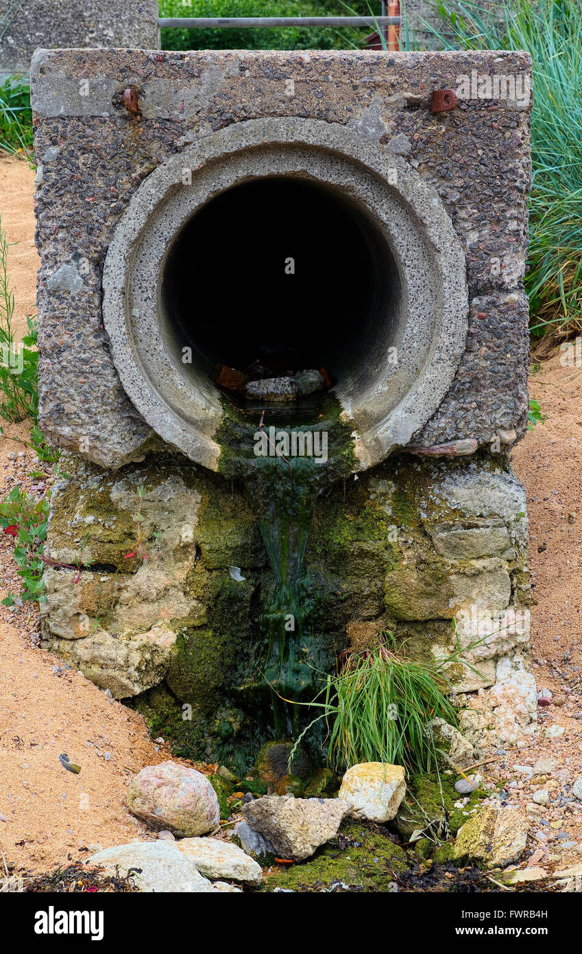 Old worn and dirty concrete water outlet in the nature Stock Photo - Alamy