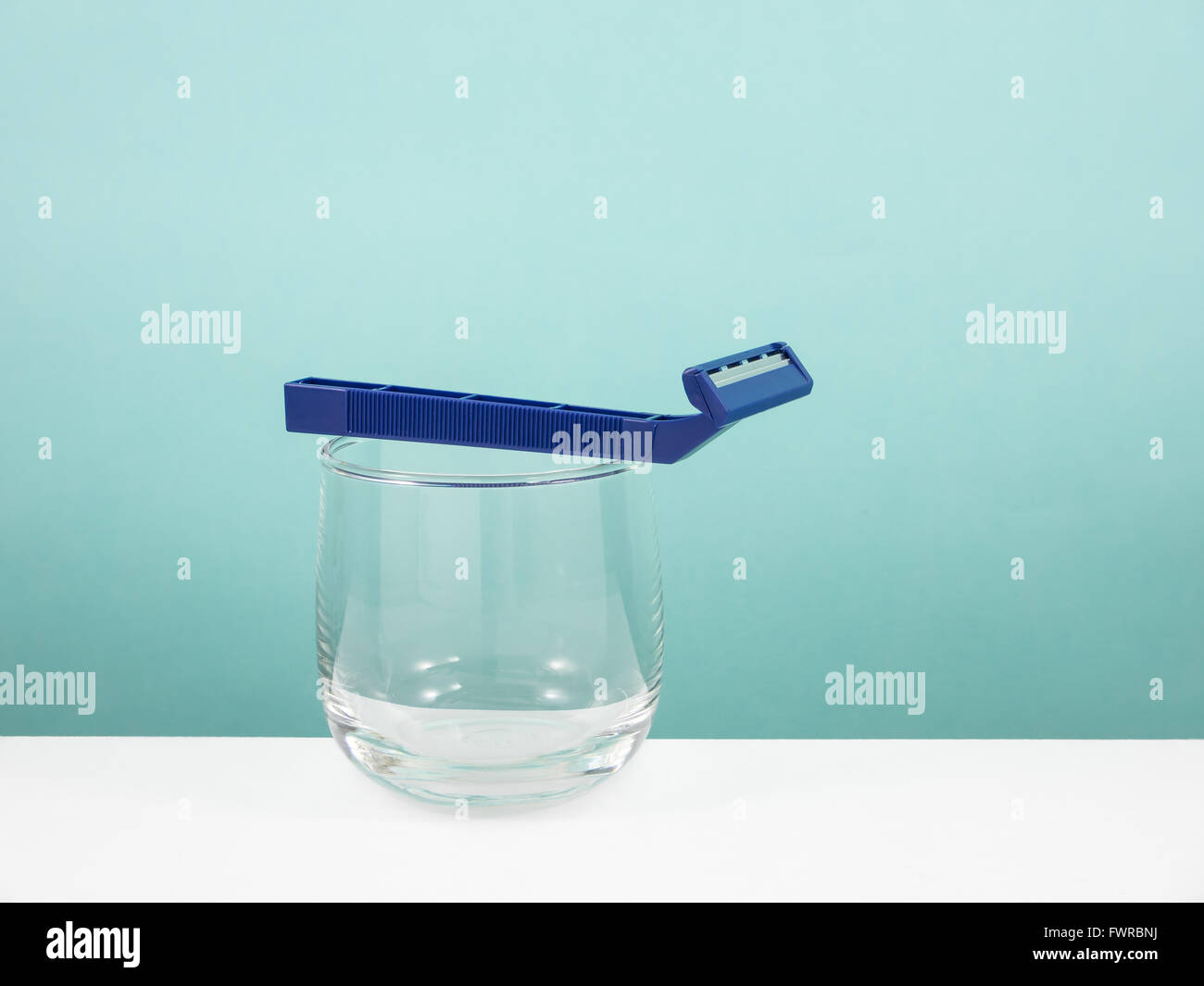 The dark blue plastic razor and round glass for men Stock Photo - Alamy