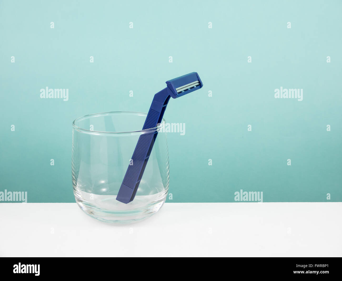The dark blue plastic razor and round glass for men Stock Photo - Alamy