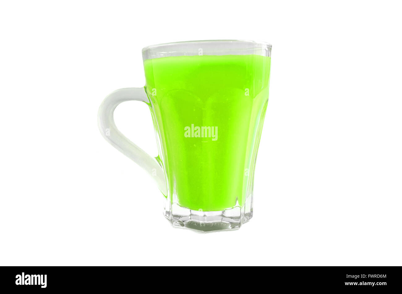 A glass cup with Green coloured liquid in it photographed against a ...