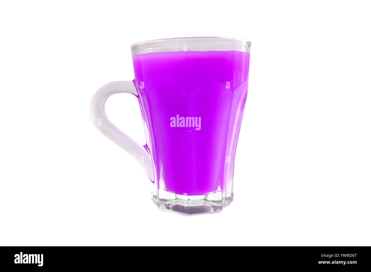 A glass cup with Purple coloured liquid in it photographed against a ...